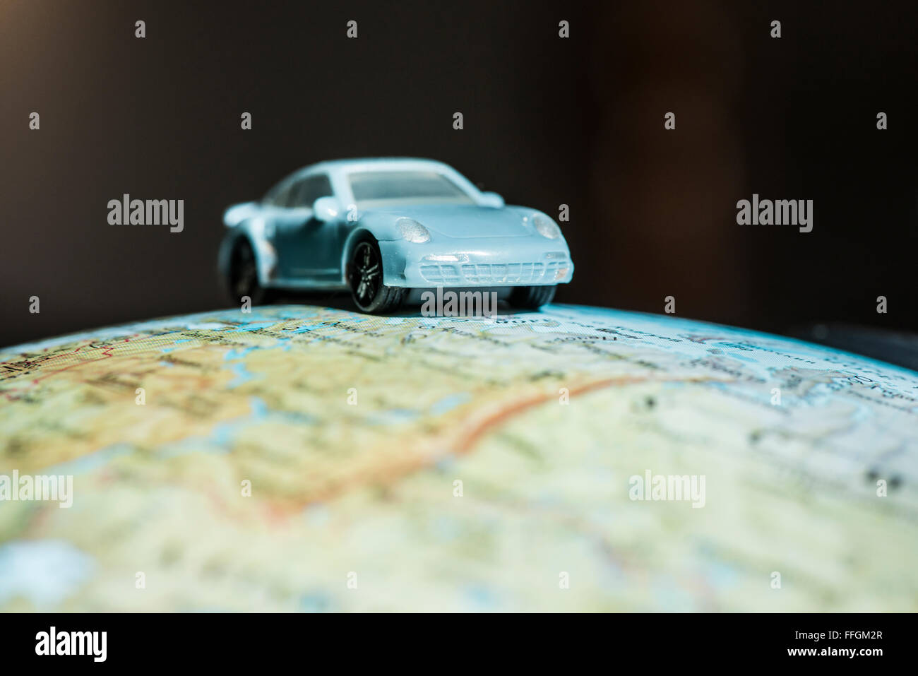 Car figure on globe. Miniature car toy Stock Photo - Alamy