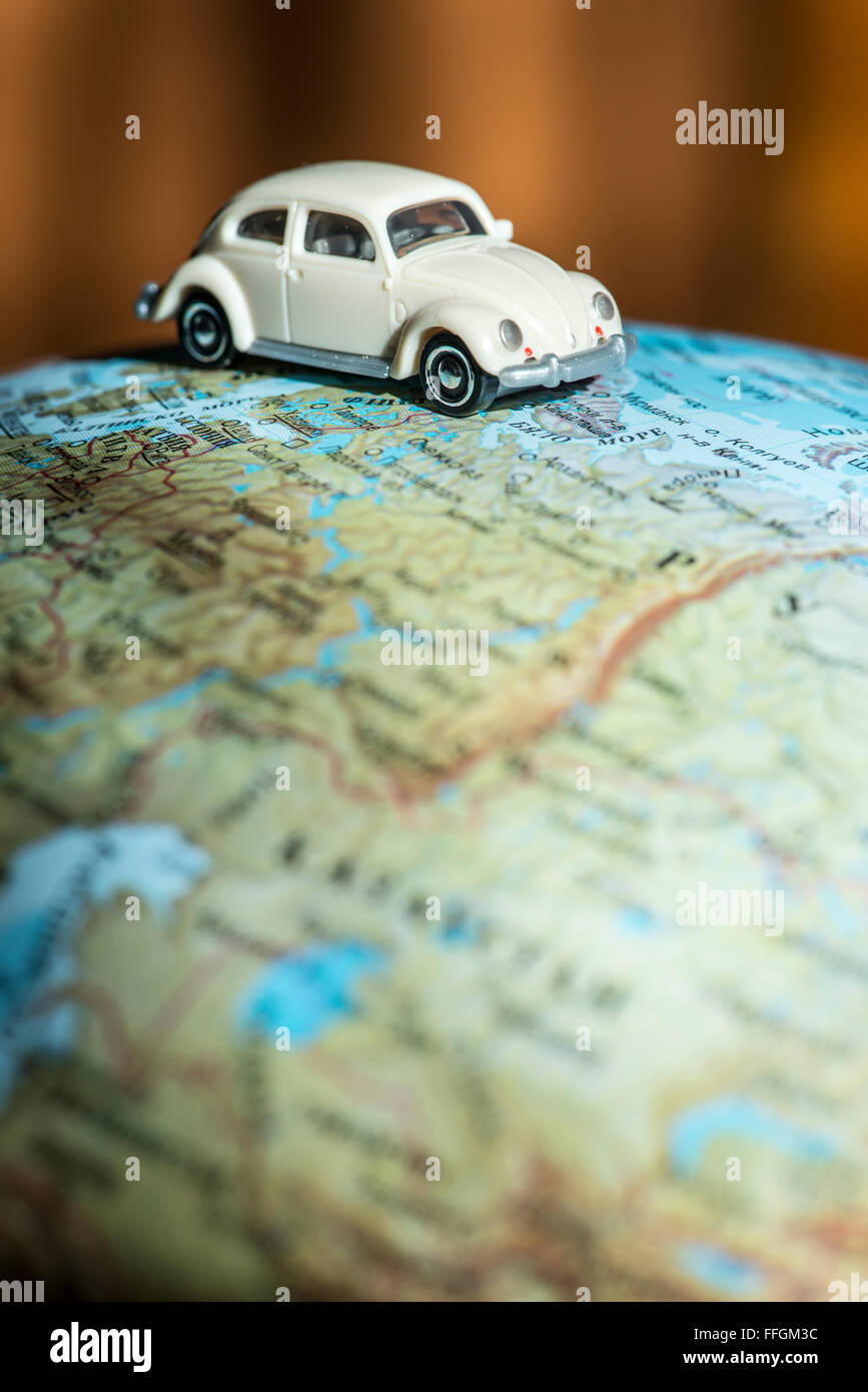 Car figure on globe. Miniature car toy Stock Photo - Alamy
