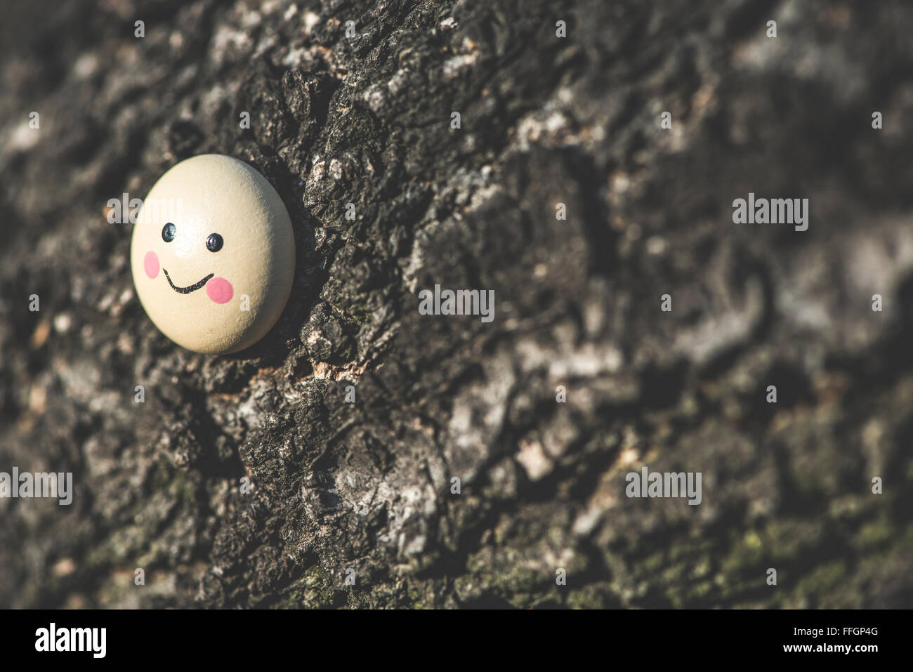 Smile icon miniature on tree twig Stock Photo - Alamy