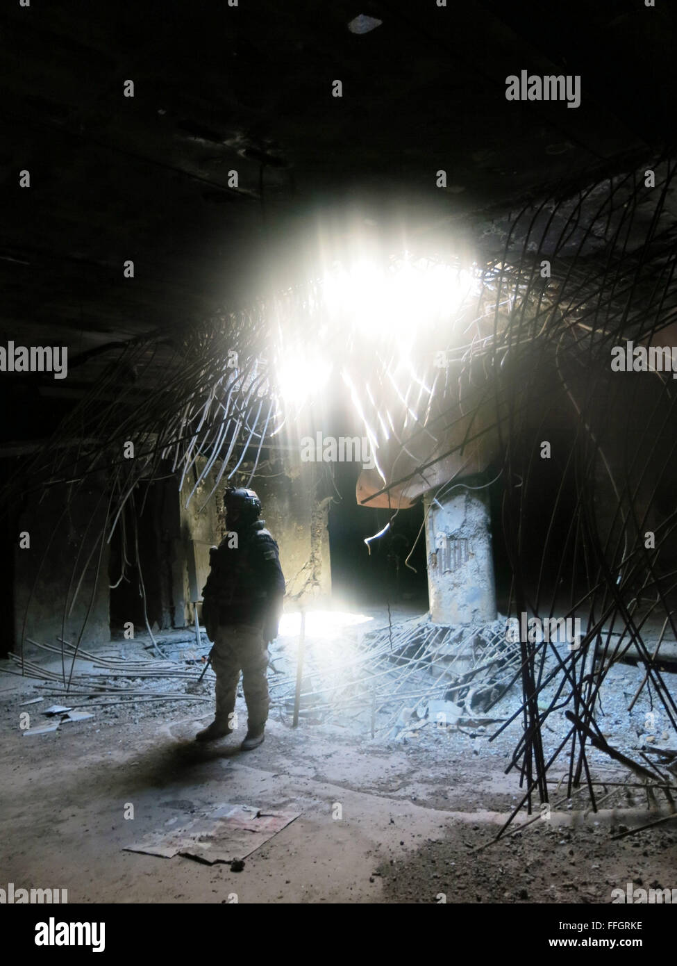 Baghdad, Iraq. 13th Feb, 2016. A soldier stands guard under a huge hole ...
