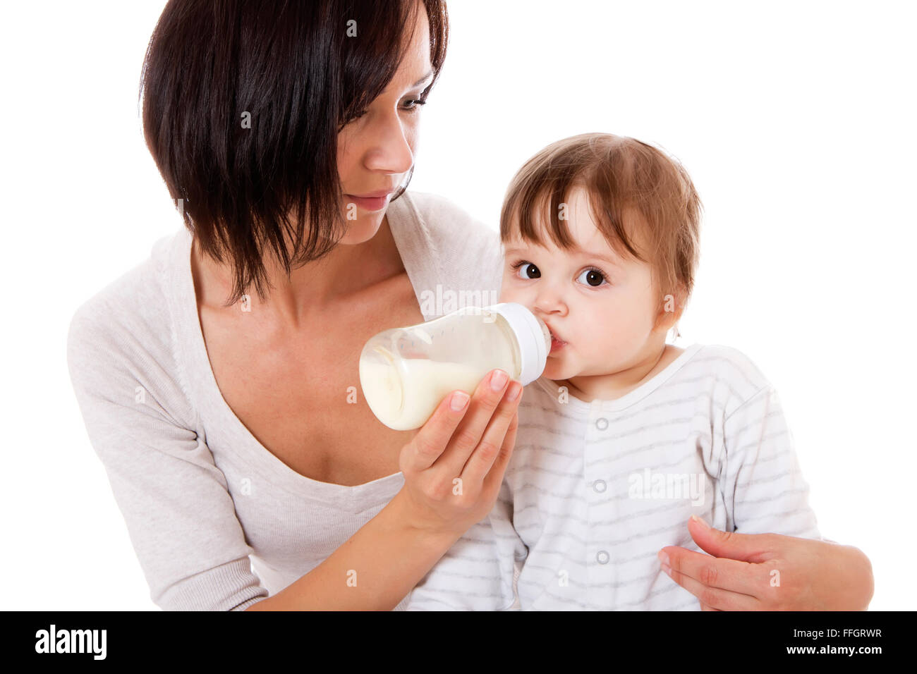 Teenage mother feeding her newborn baby with the bottle. Isolsted on ...