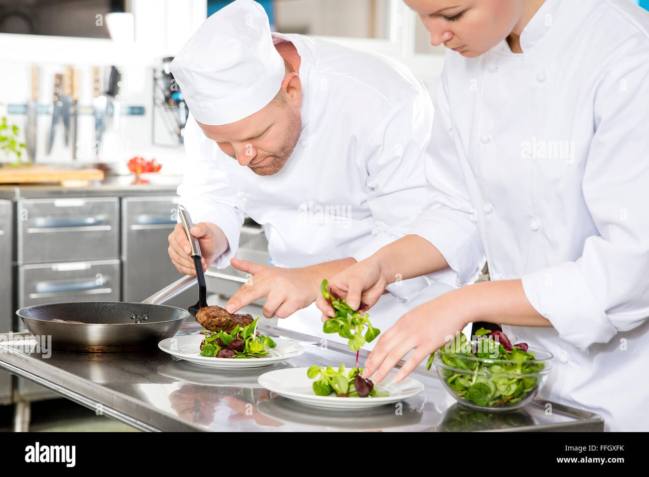 Two chefs prepares steak dish at gourmet restaurant Stock Photo - Alamy