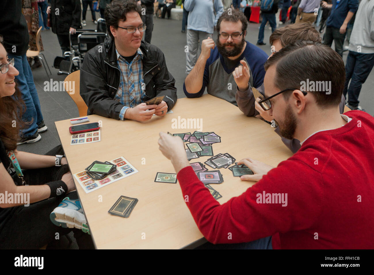Young people playing cards at table - USA Stock Photo - Alamy