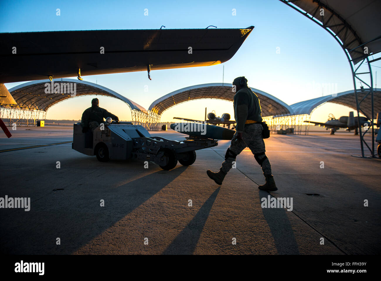 U.S. Air Force weapons advisors maneuver 500 pound inert training bombs ...