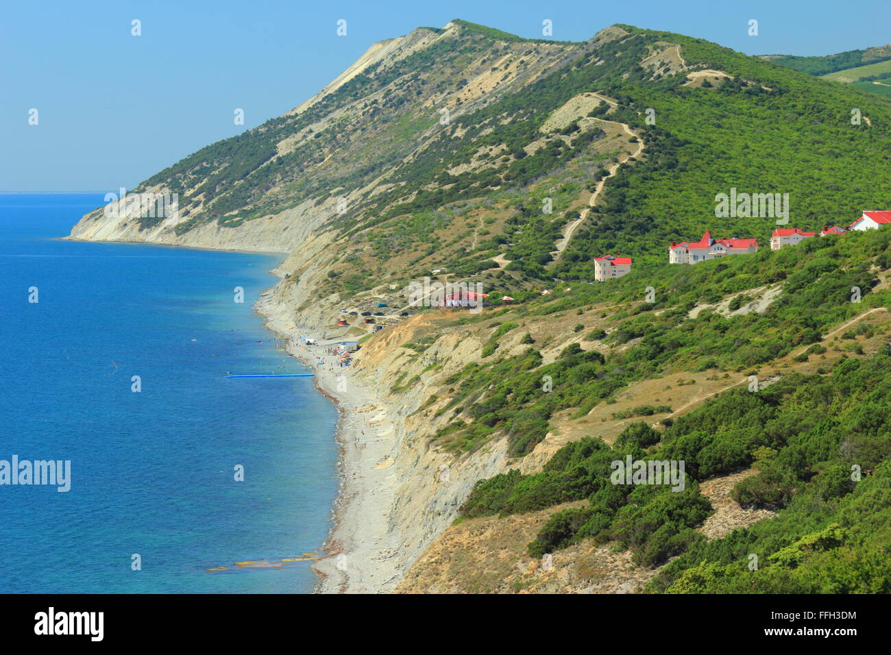 View on sea coast with a high mountain ridge with steep slopes and ...