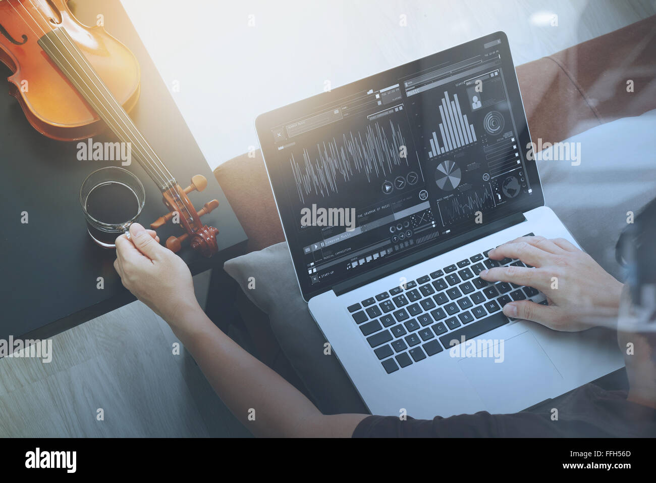 hipster hand composing music with laptop compter and sitting on sofa at ...