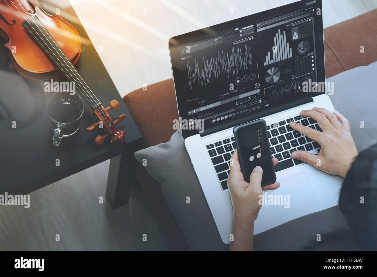 hipster hand composing music with smart phone and laptop compter and ...