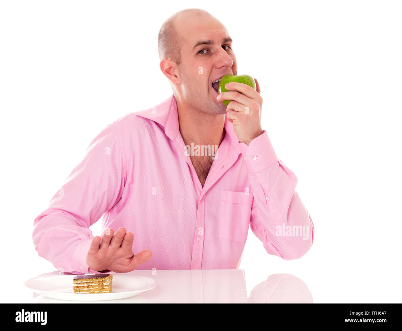 Caucasian man eating apple instead of cake, isolated on white ...