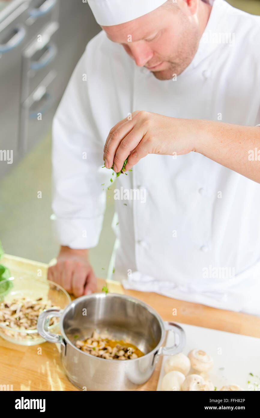 Professional chef making garnish in large kitchen Stock Photo - Alamy