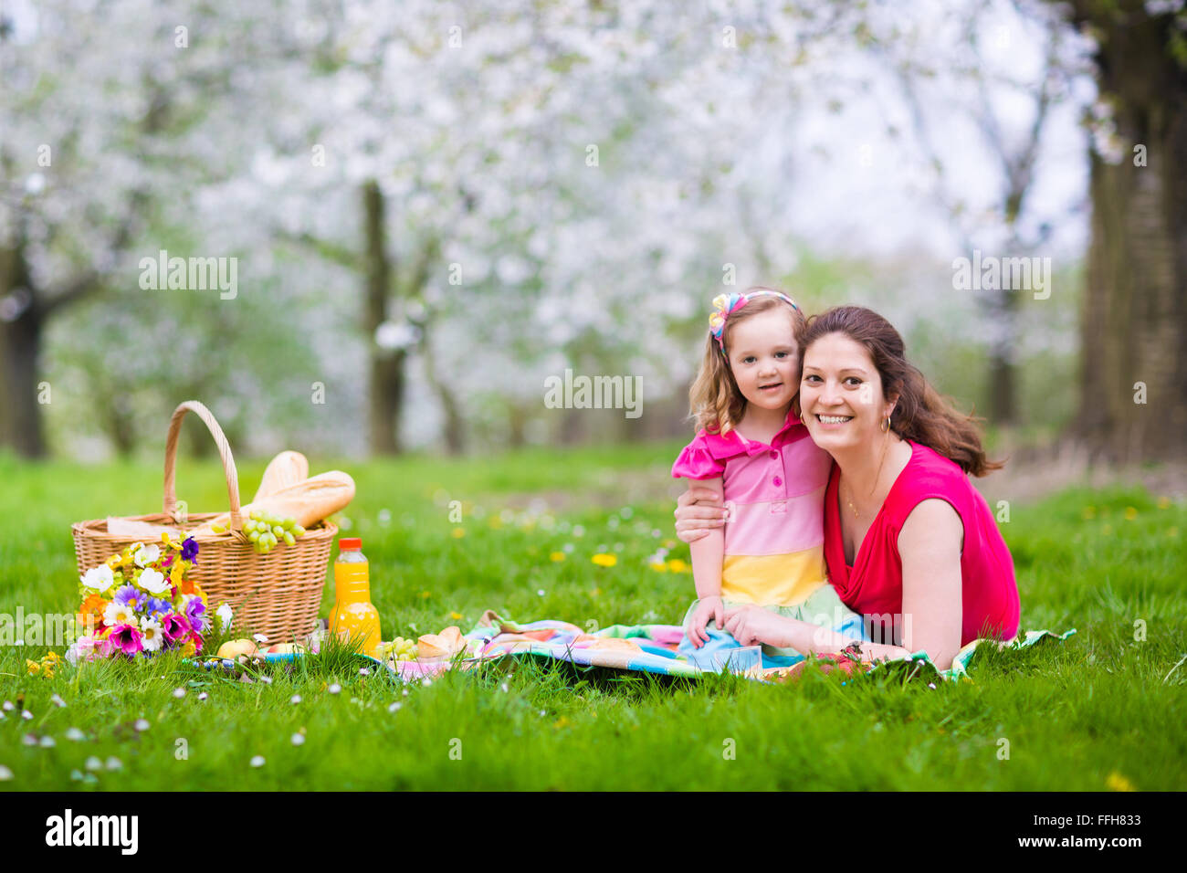 Family with children enjoying picnic in spring garden. Parents and kids ...
