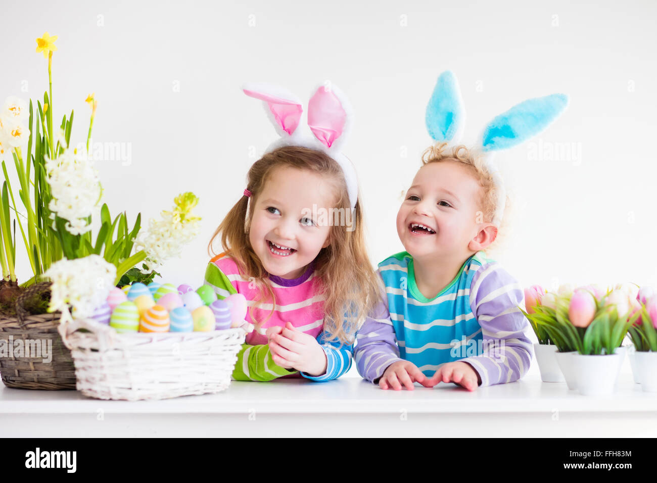 Happy children celebrate Easter at home. Boy and girl wearing bunny ...