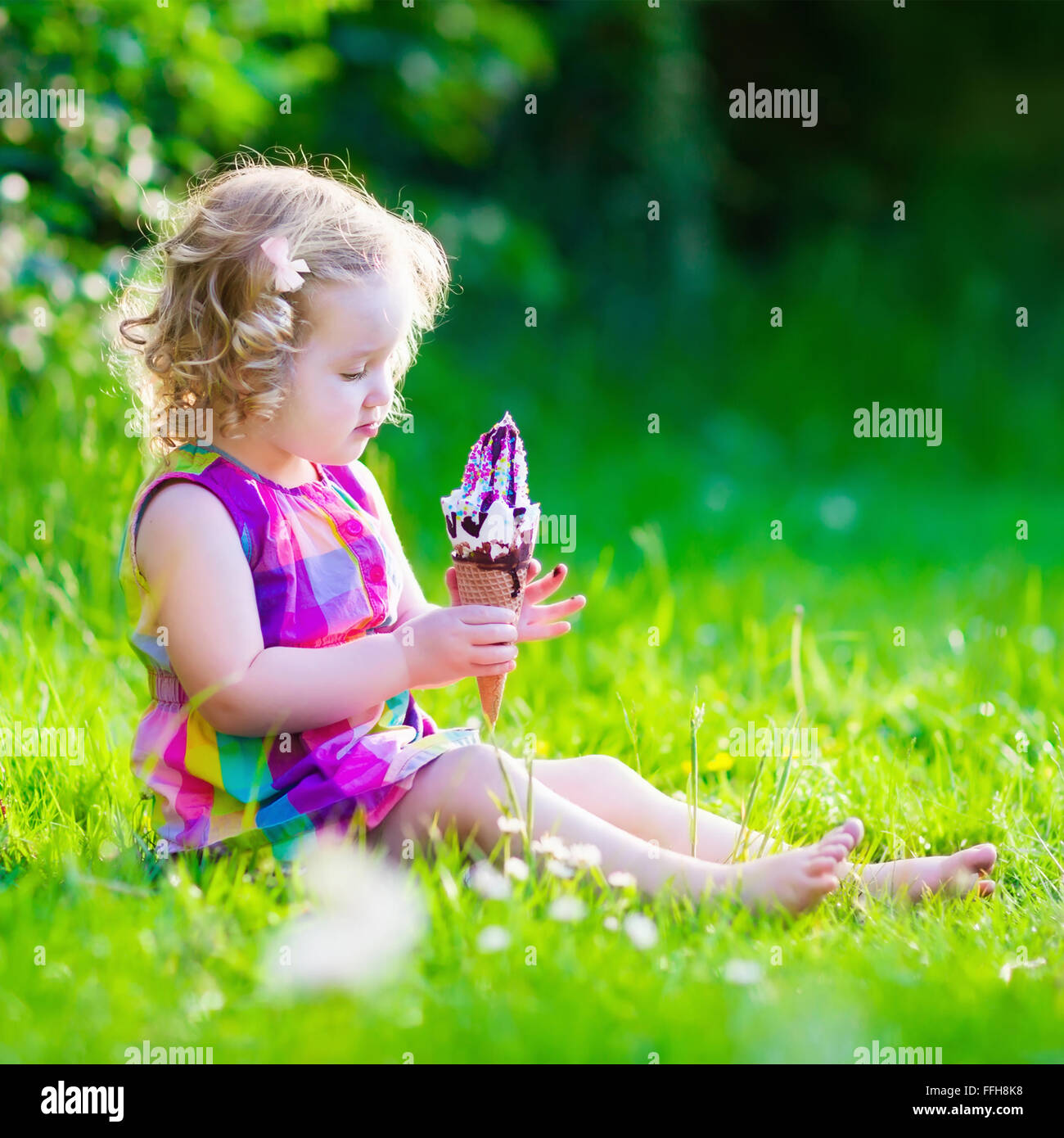 Child eating ice cream. Kids play outdoors enjoying sweet snack on a ...