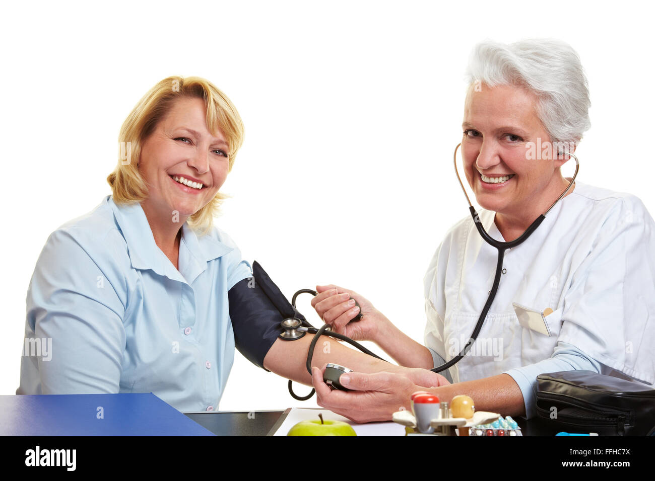Happy woman getting blood pressure measure at health check Stock Photo ...