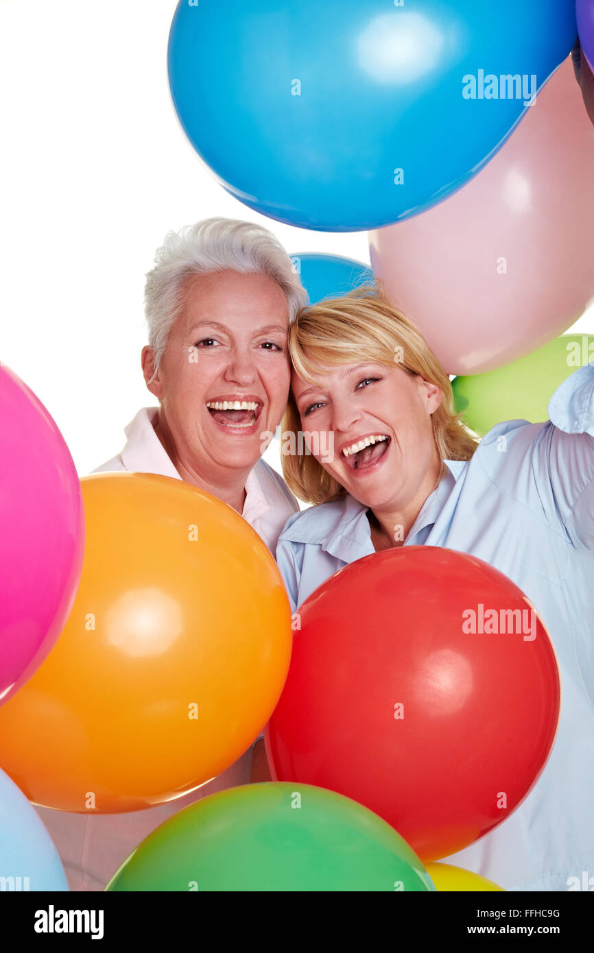 Two happy senior women cheering with many balloons Stock Photo - Alamy