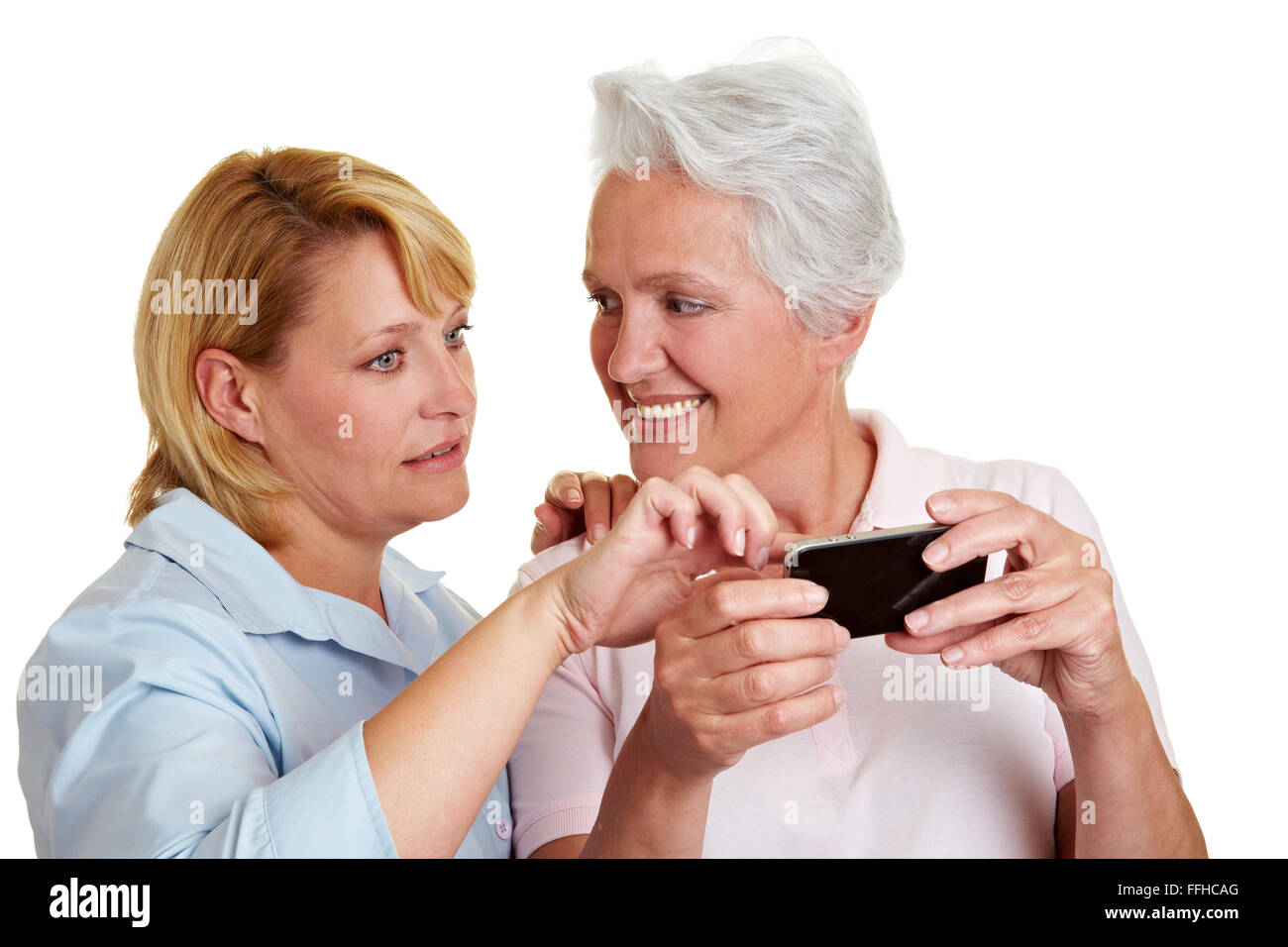 Woman explaining smiling senior woman a smartphone Stock Photo - Alamy