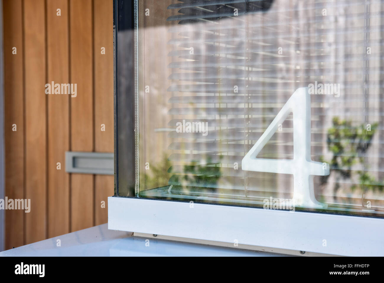 A eree standing white number 4 in the window of a home denoting the ...