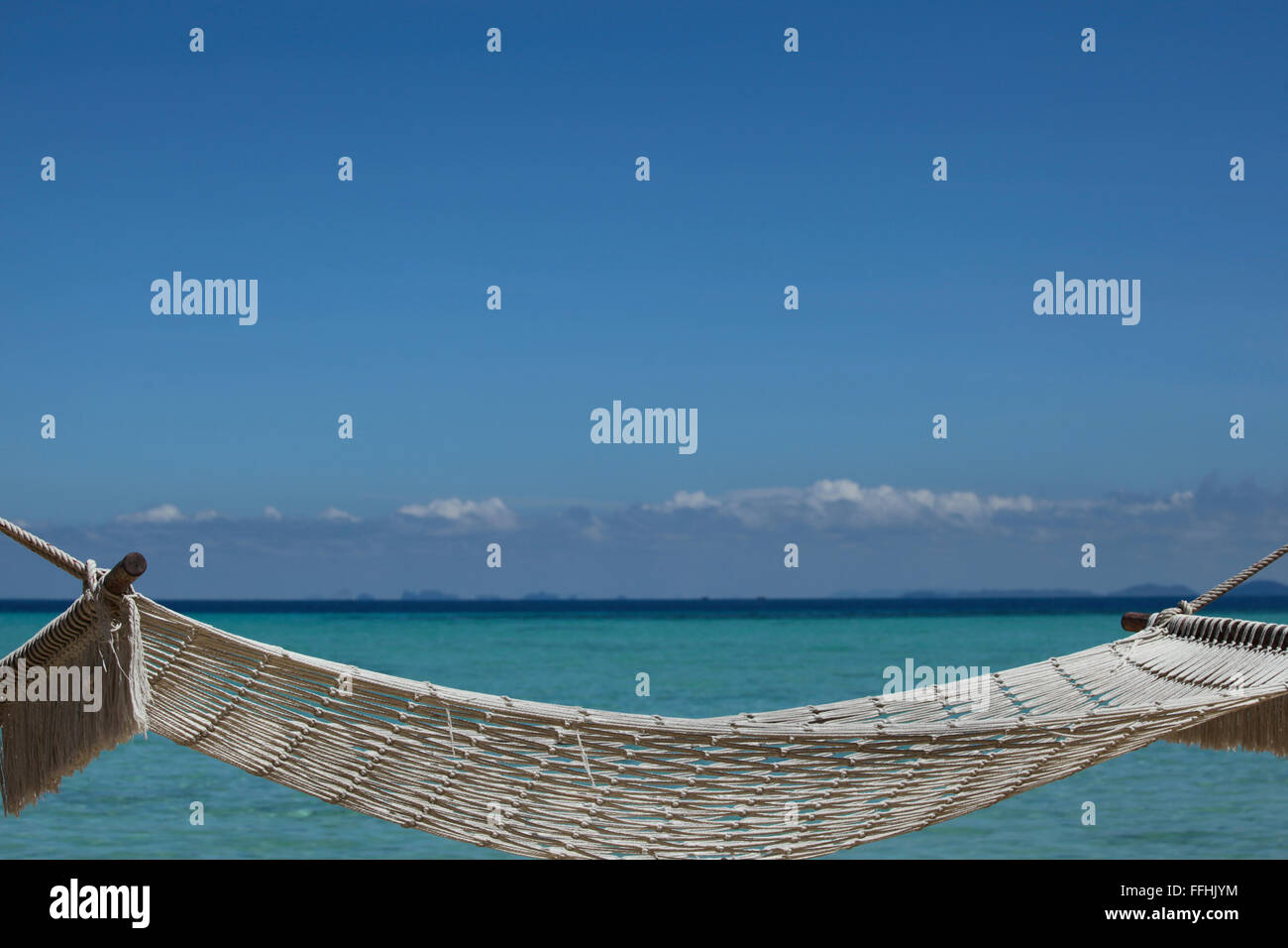 Empty hammock on beach ober blue sea background Stock Photo - Alamy