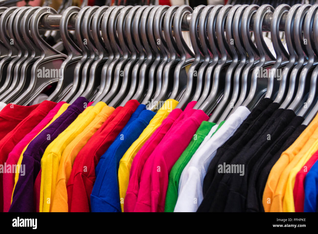 Colorful t-shirts on hangers on rack Stock Photo - Alamy