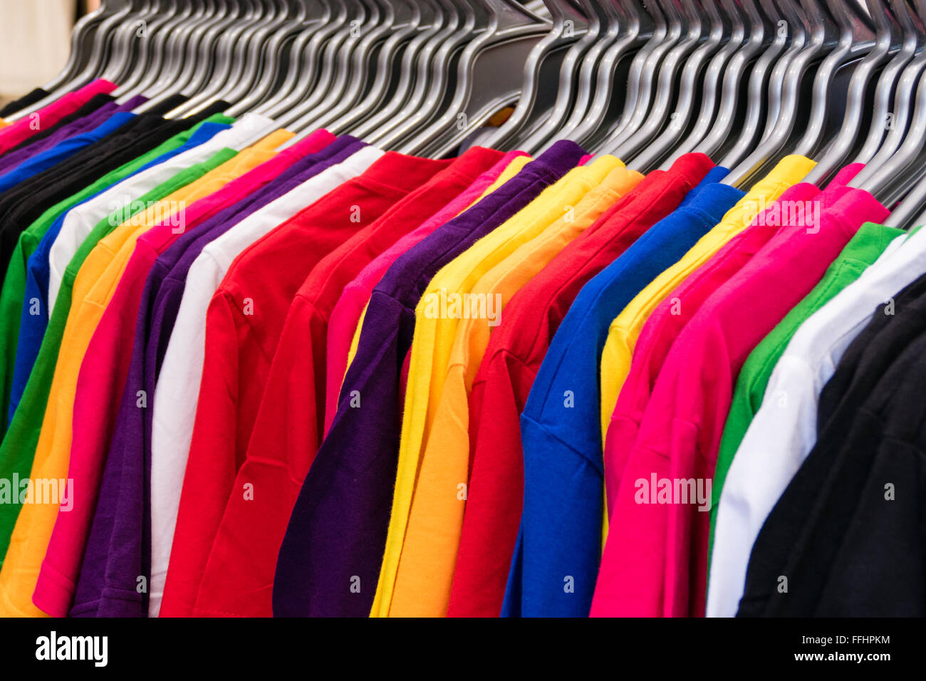 Colorful t-shirts on hangers on rack Stock Photo - Alamy