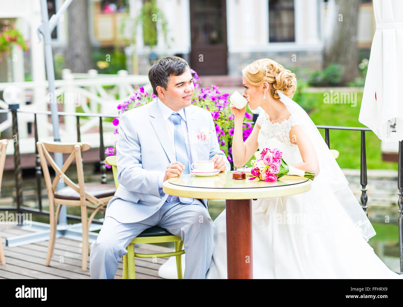 Bride and groom drinking coffee at an outdoor cafe Stock Photo - Alamy