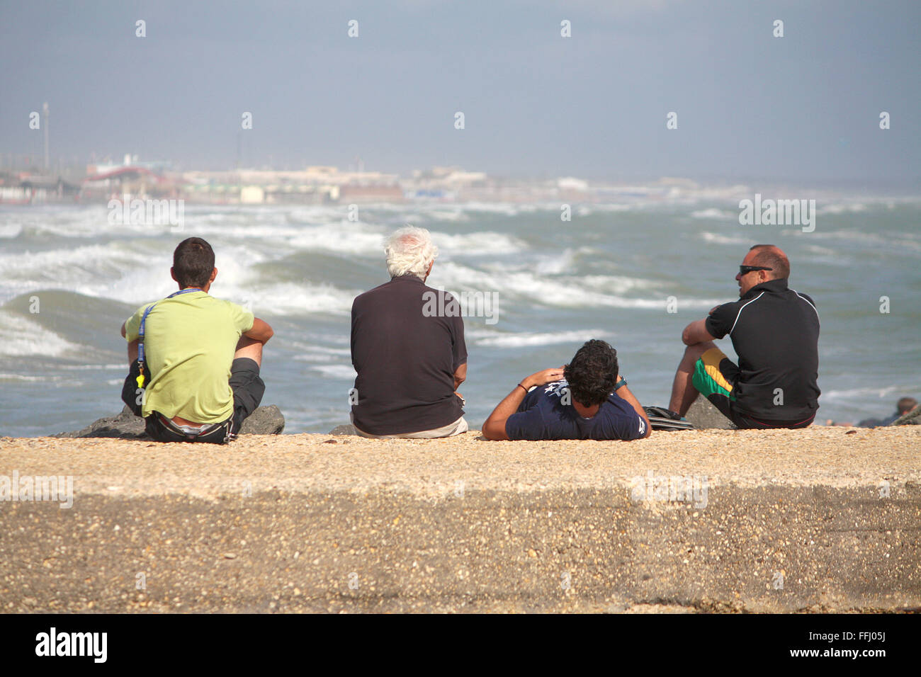 OSTIA, ITALY - JUNE 2010: Four friends sit together over a little ...