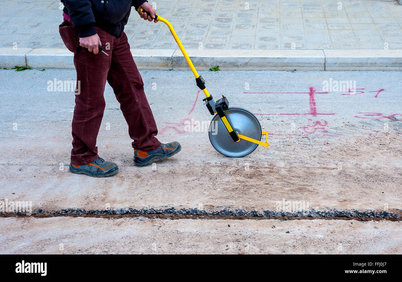 Surveyor with measuring wheel (odometer) detects the length of an ...