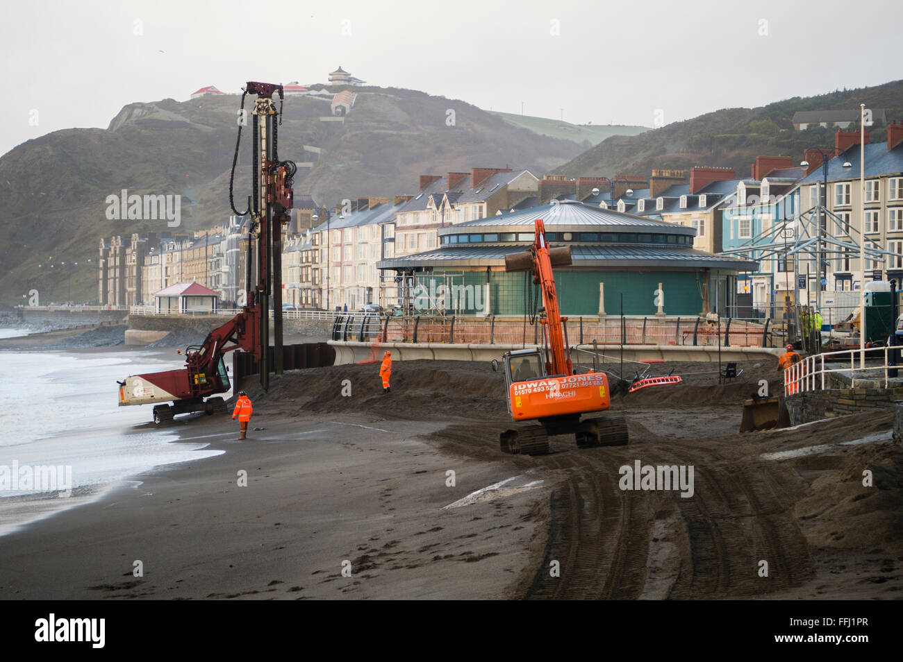 Construction workers removing the steel protective barrier from around ...