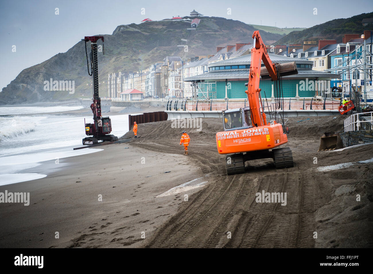 Construction workers removing the steel protective barrier from around ...