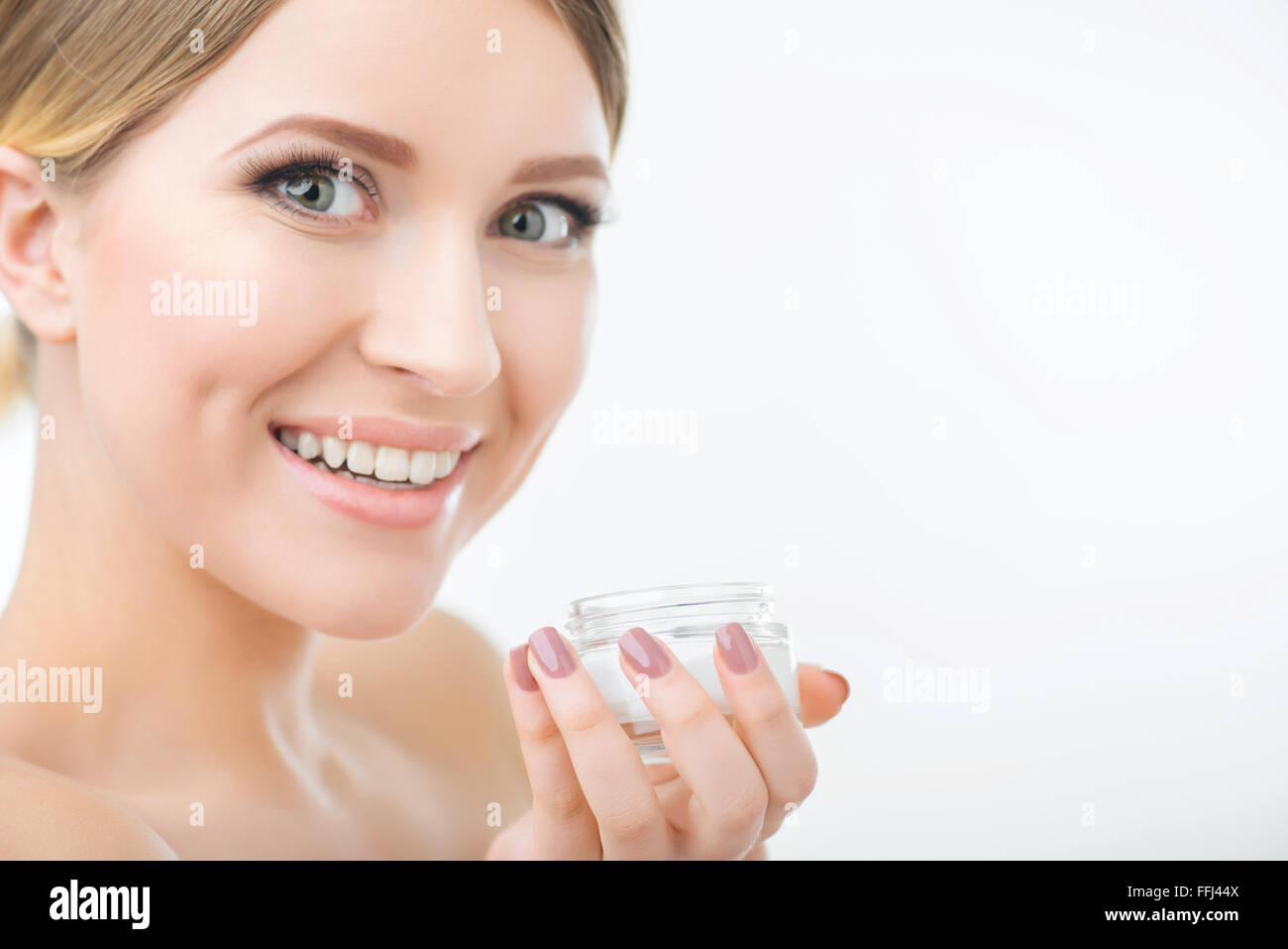 Beautiful woman holding face cream Stock Photo - Alamy