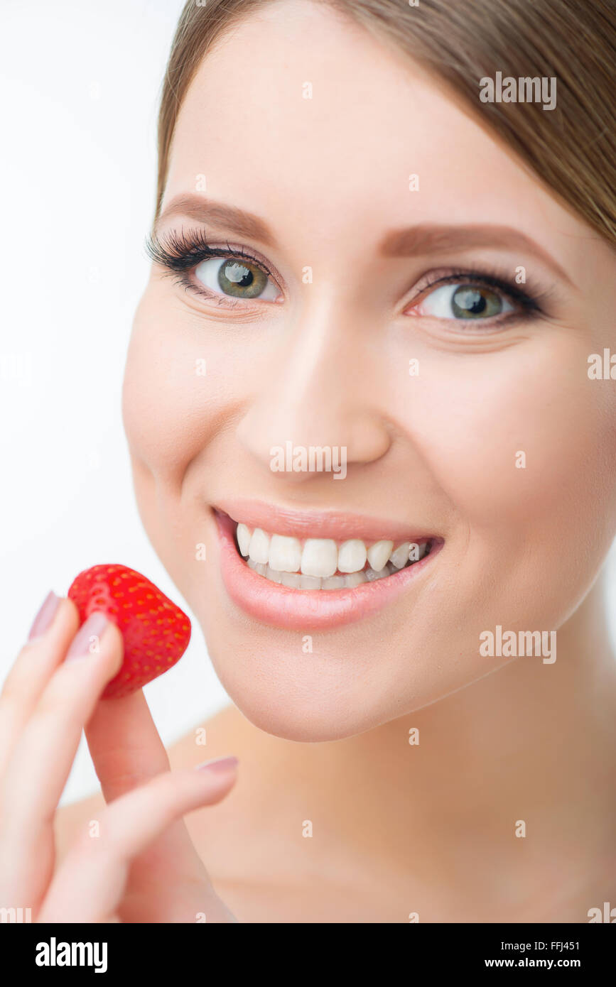 Smiling woman eating strawberry Stock Photo - Alamy