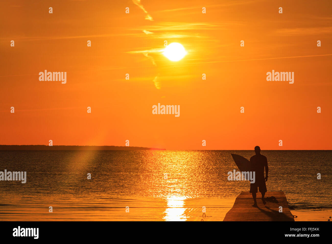 Man Surfing sunset Stock Photo - Alamy