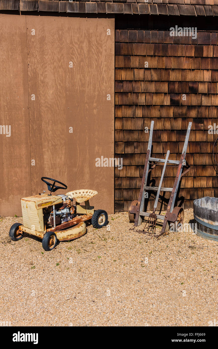 Farm equipment still life placed in front of a farm building with a ...