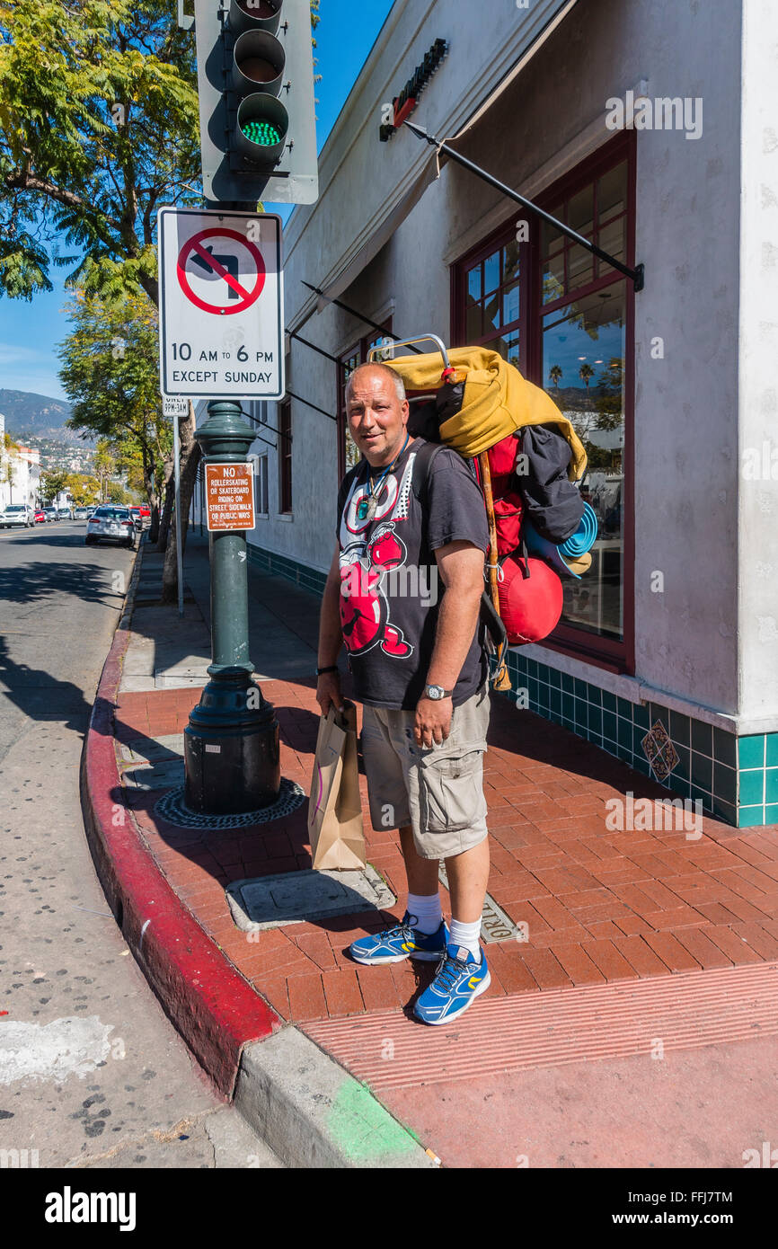 An older transient male backpacker carries his world possessions on his ...