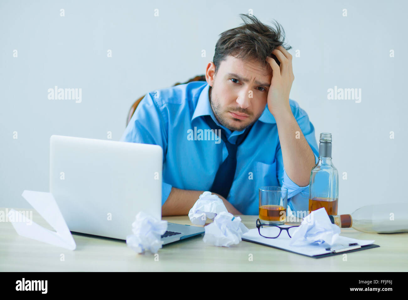 Drunk man drinking alcohol while working Stock Photo - Alamy