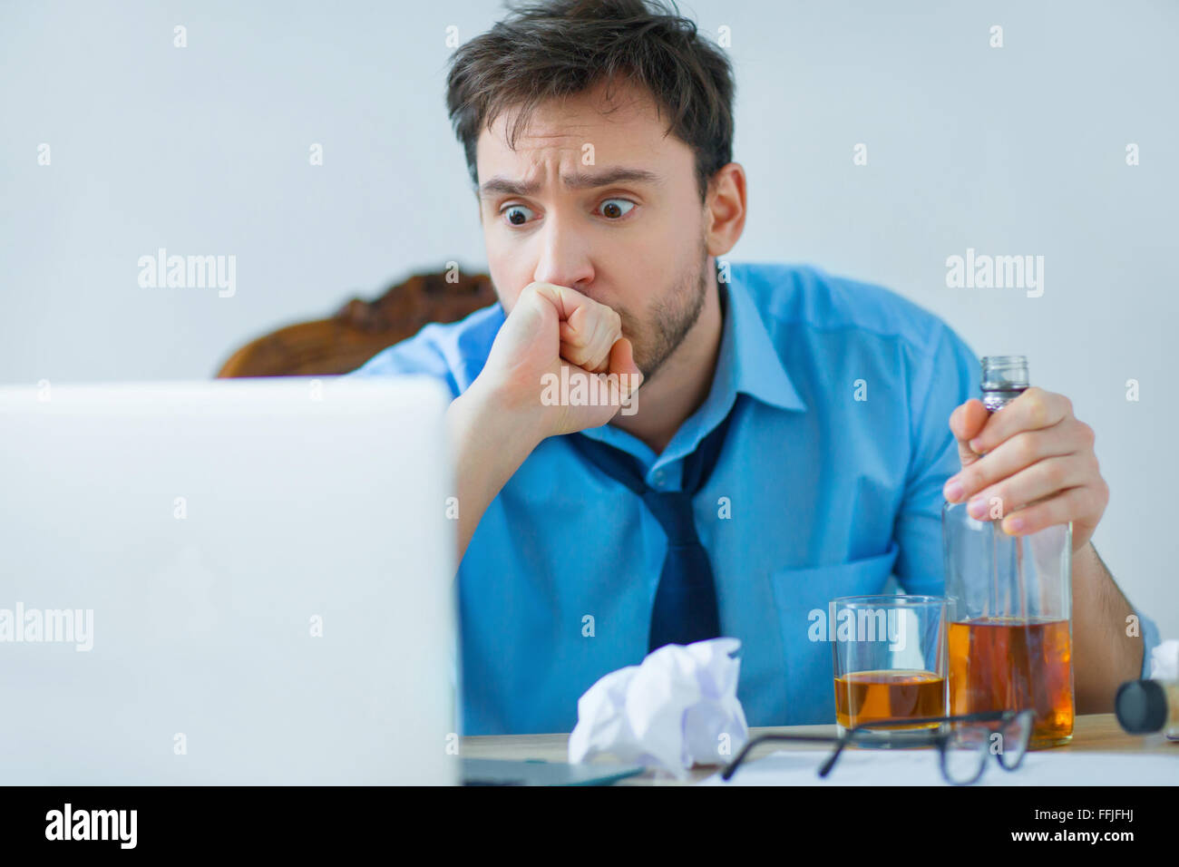 Drunk man drinking alcohol while working Stock Photo - Alamy