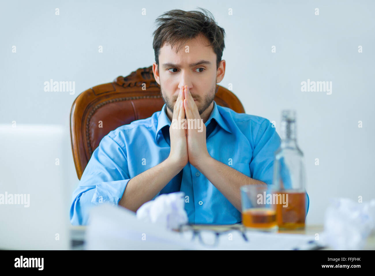 Drunk man drinking alcohol while working Stock Photo - Alamy