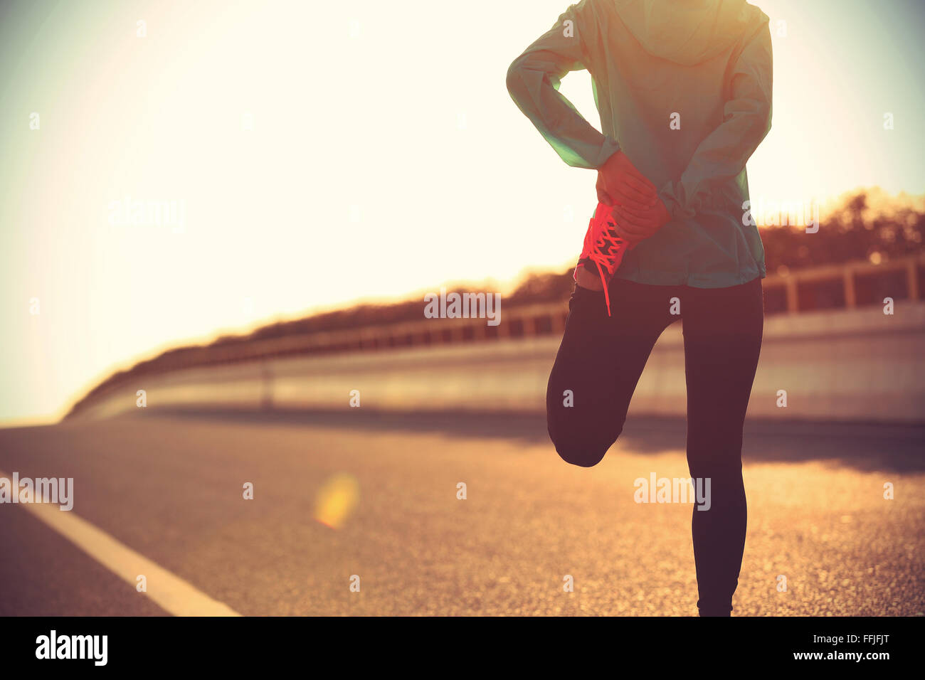 young fitness woman runner stretching legs before run Stock Photo - Alamy