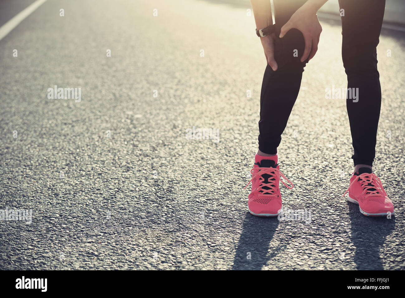 woman runner hold her injured leg on road Stock Photo - Alamy