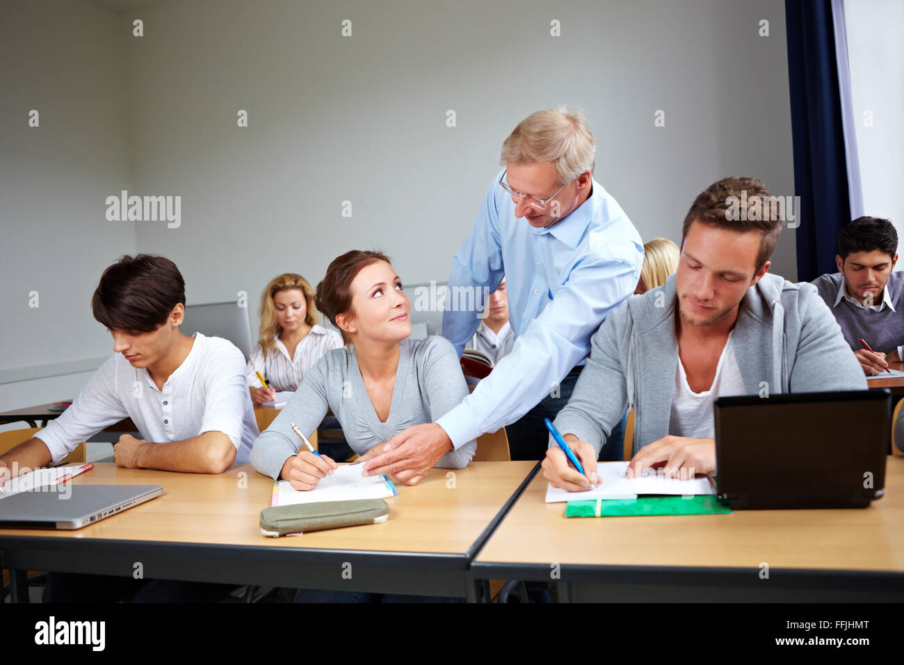 Assistance of students at university with a teacher Stock Photo - Alamy