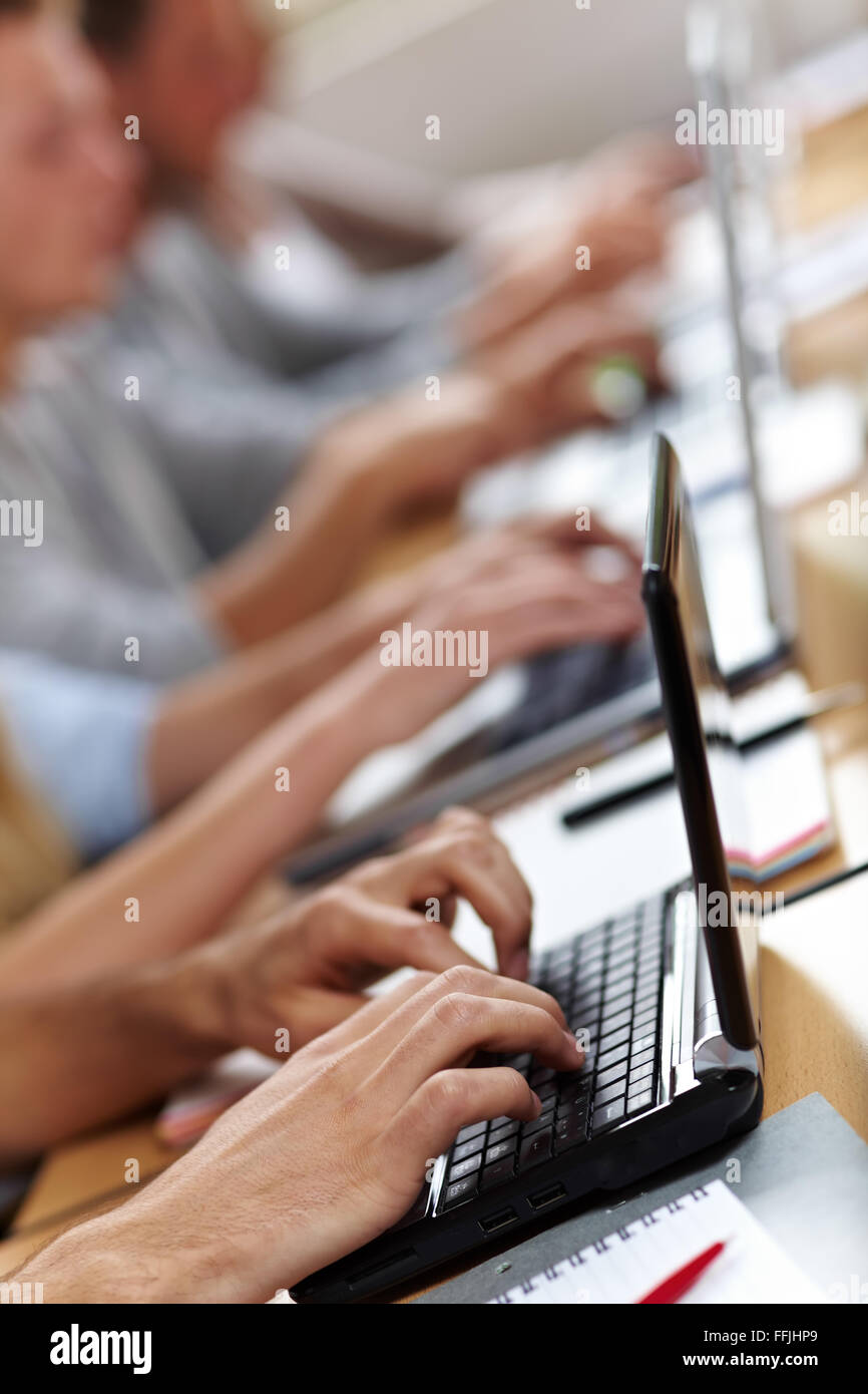 Many hands typing on laptops or netbooks Stock Photo - Alamy