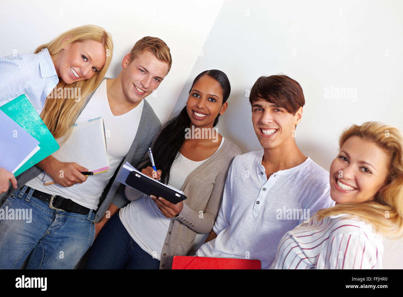 Happy young students smiling in school hall Stock Photo - Alamy
