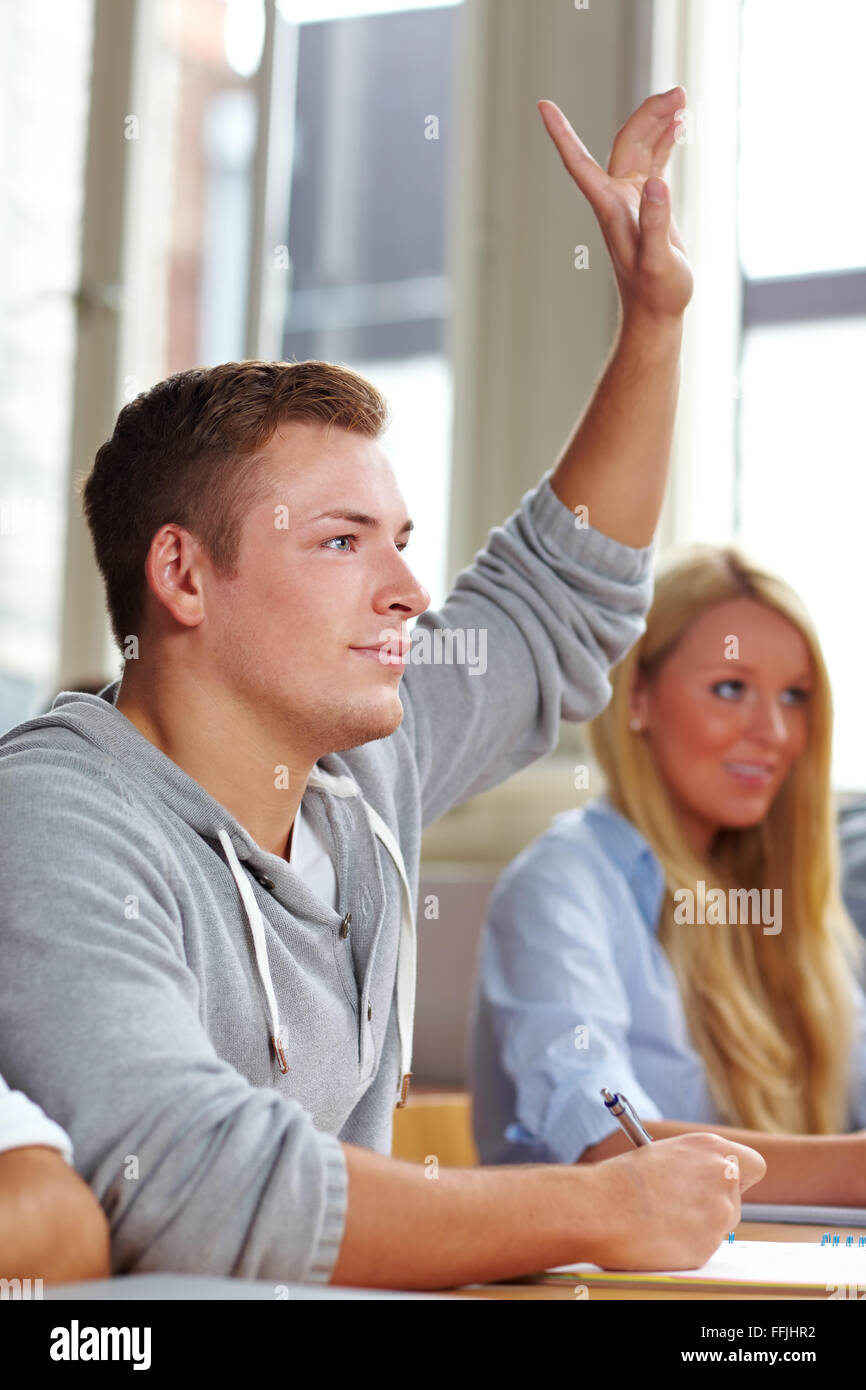 Student raising his hand in university class Stock Photo - Alamy