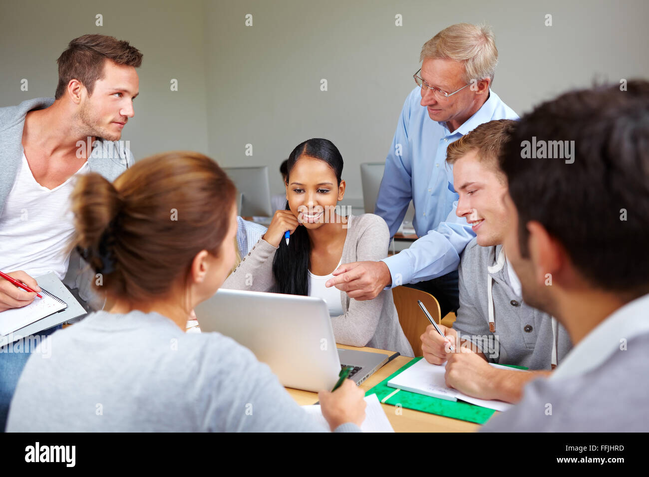 Teacher with students together in a college class Stock Photo - Alamy