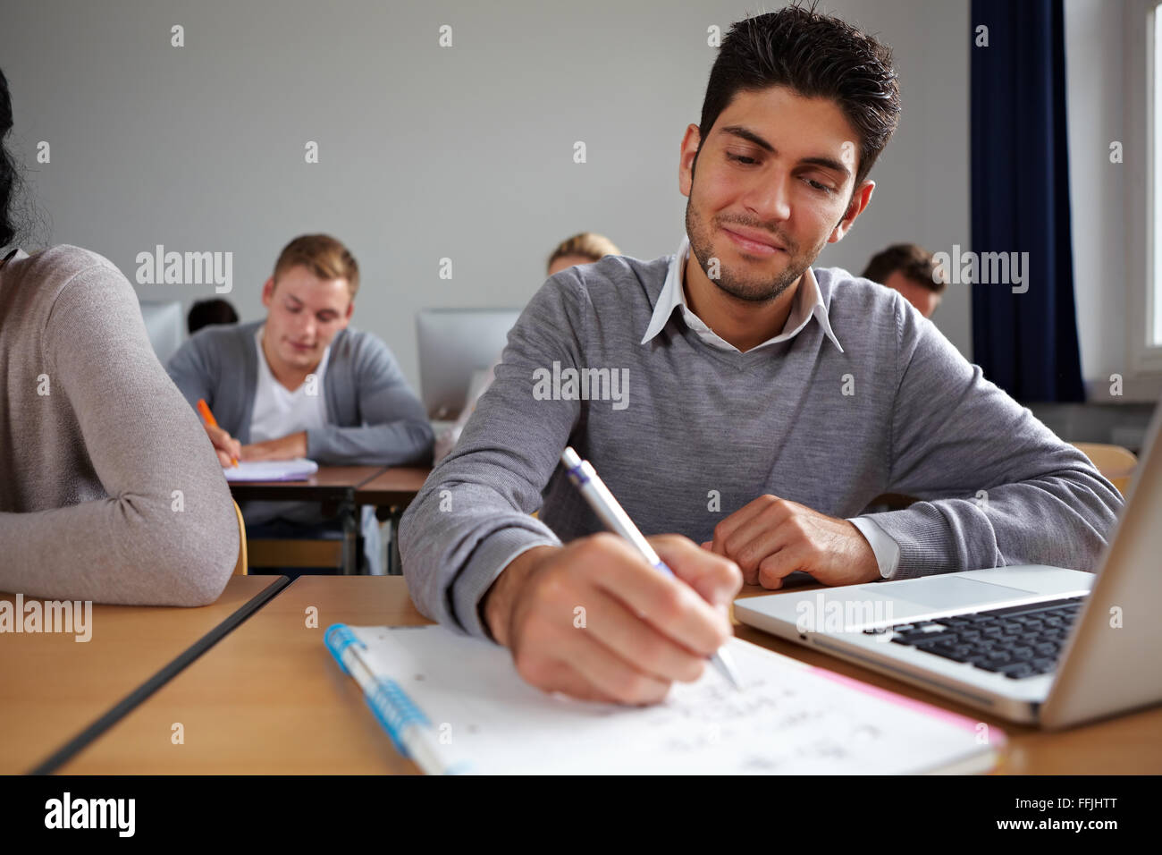Student with computer taking notes in university class Stock Photo - Alamy