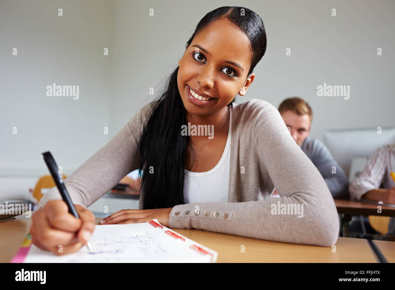 Happy african girl in school taking notes Stock Photo - Alamy