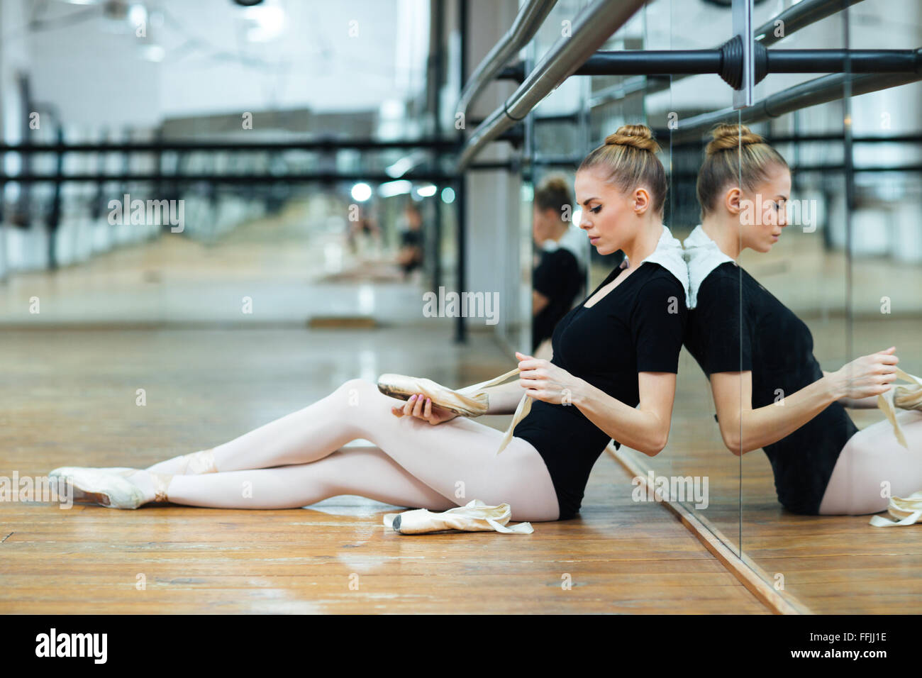 Young woman resting on the floor in ballet class Stock Photo - Alamy