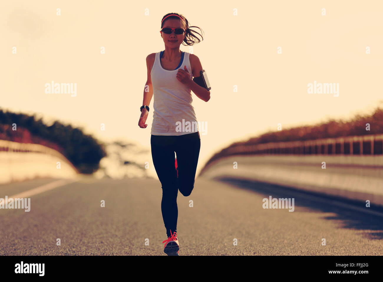 young sports woman runner running on city road Stock Photo - Alamy