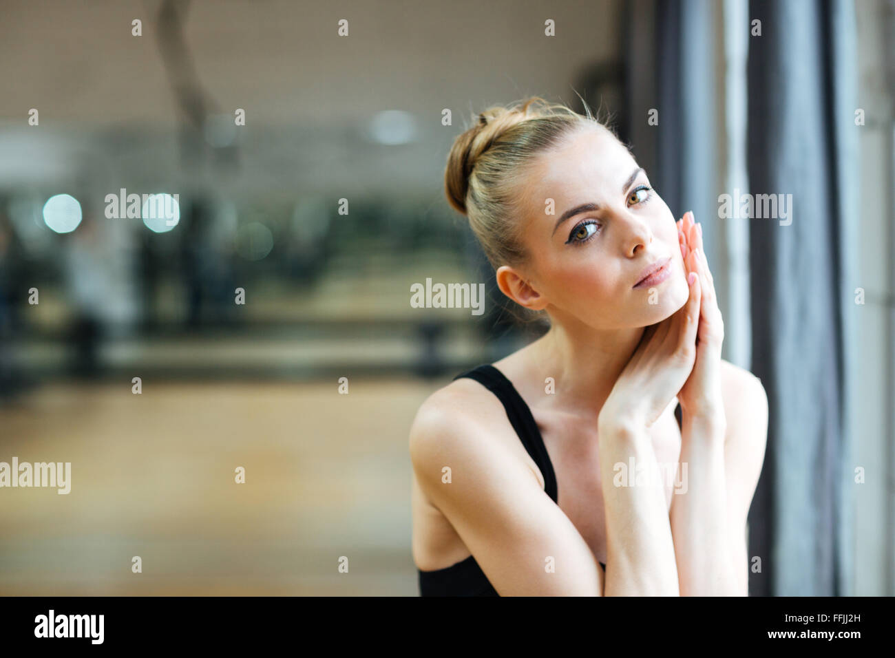 Young ballerina resting in ballet class and looking at camera Stock ...
