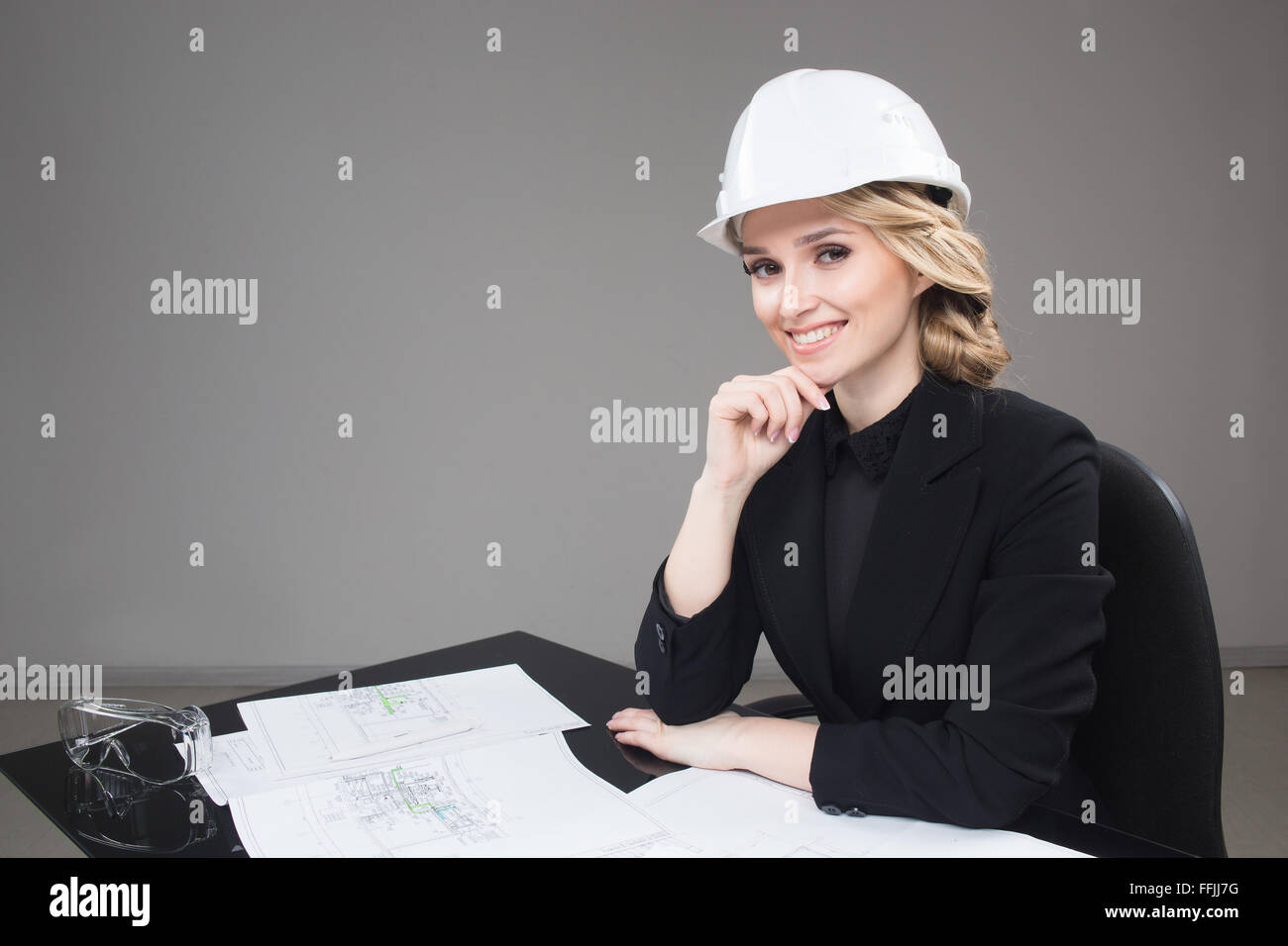 Woman architect with drawings. Beautiful girl in a building helmet ...