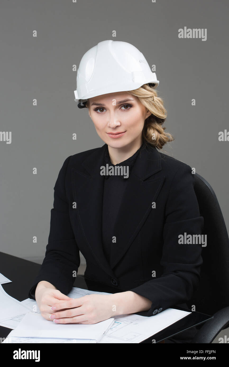 Woman architect with drawings. Beautiful girl in a building helmet ...